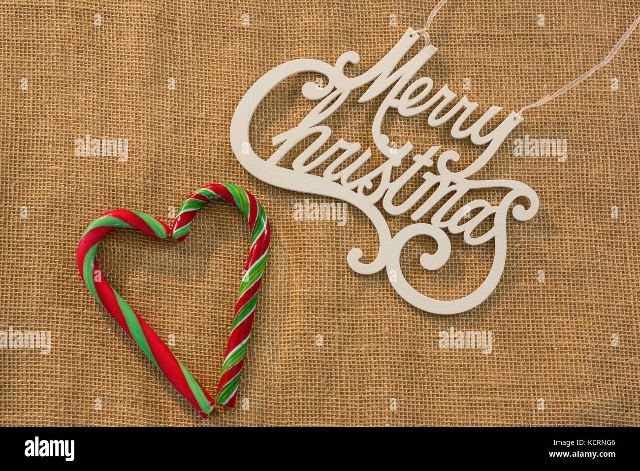 Merry Christmas text with candy canes on burlap Stock Photo - Alamy