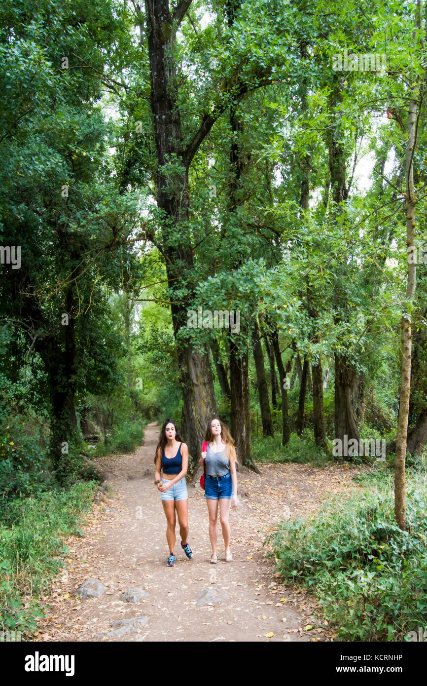 Two beautiful women hiking in nature on a mountain road Stock Photo - Alamy