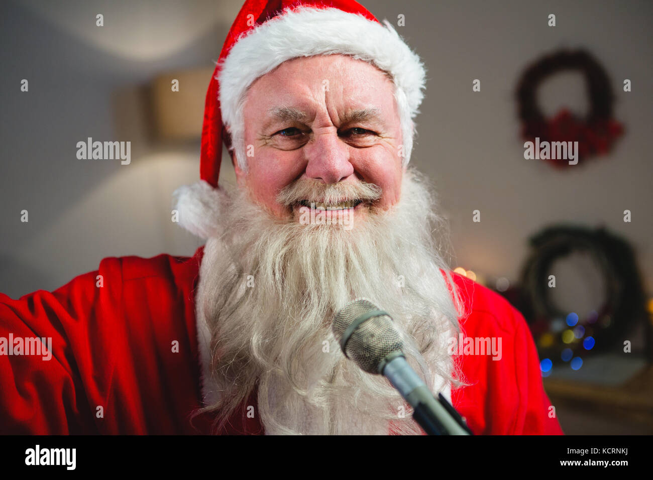 Smiling of santa claus singing a christmas songs at home during ...