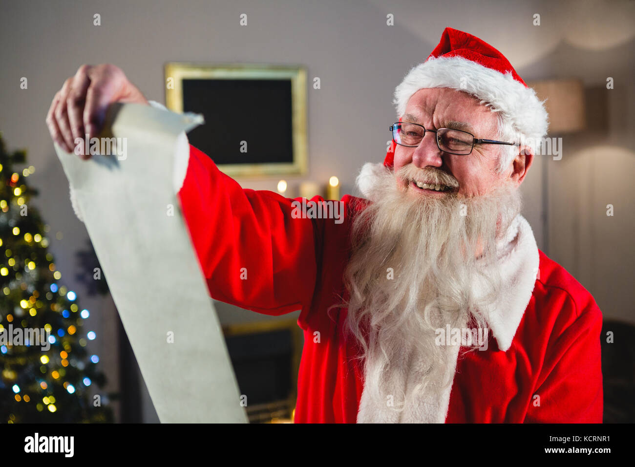 Santa Claus reading scroll in living room at home Stock Photo - Alamy