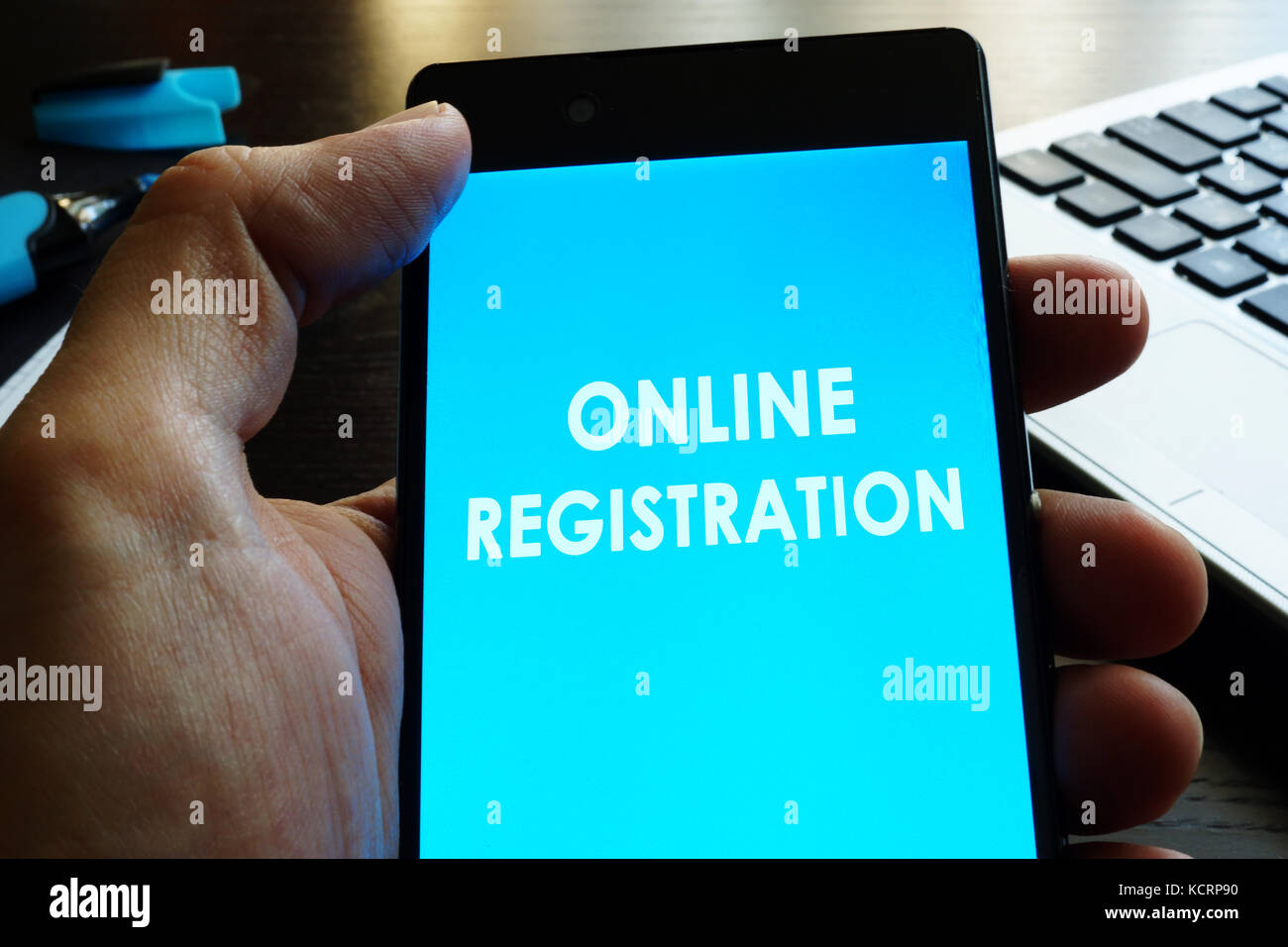 Man holding smart phone with online registration Stock Photo - Alamy