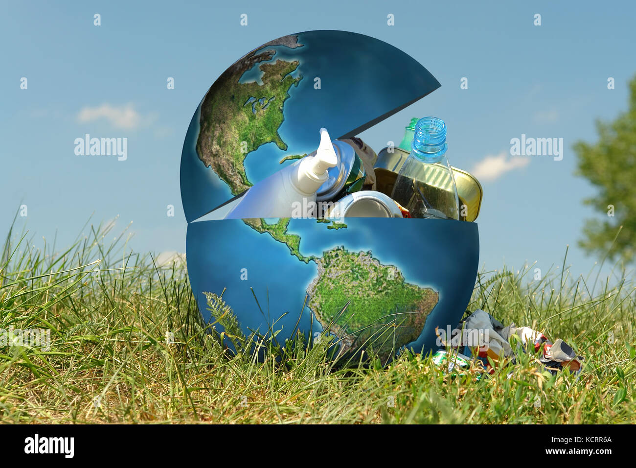 Earth globe in grass filled with assorted trash - concept representing ...