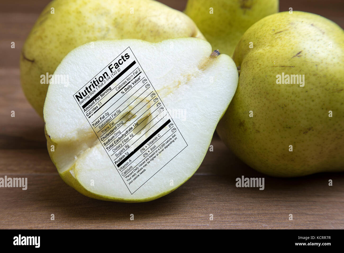 Close up of fresh raw whole and cut green pears with nutritional facts ...