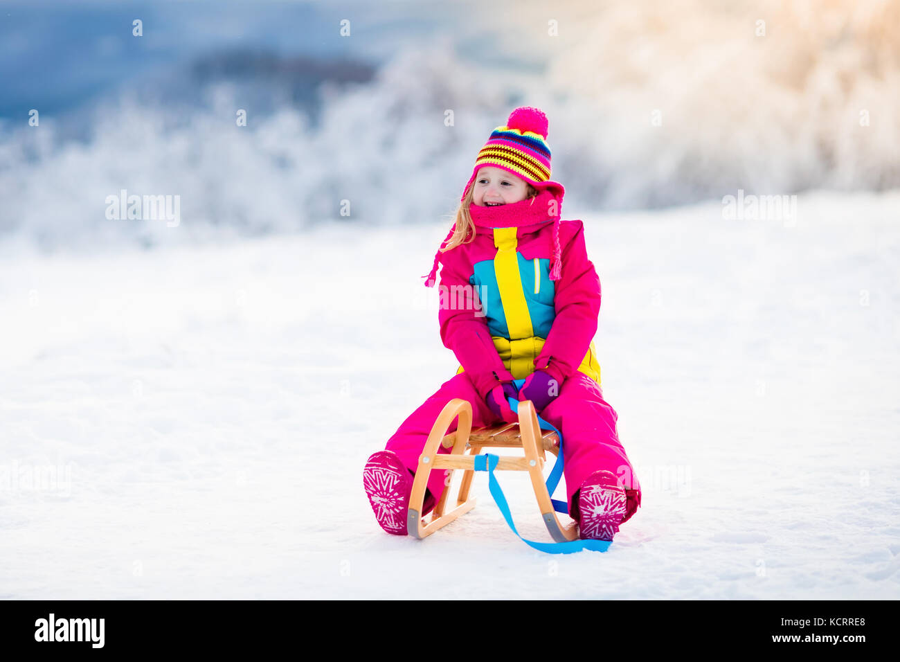 Little girl enjoying a sleigh ride. Child sledding. Toddler kid riding ...