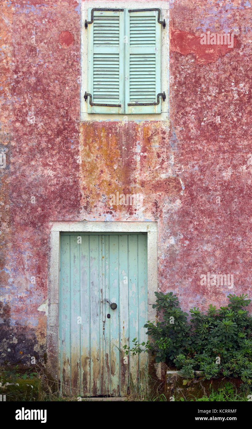 an old greek building in a poor state of repair with peeling green and ...