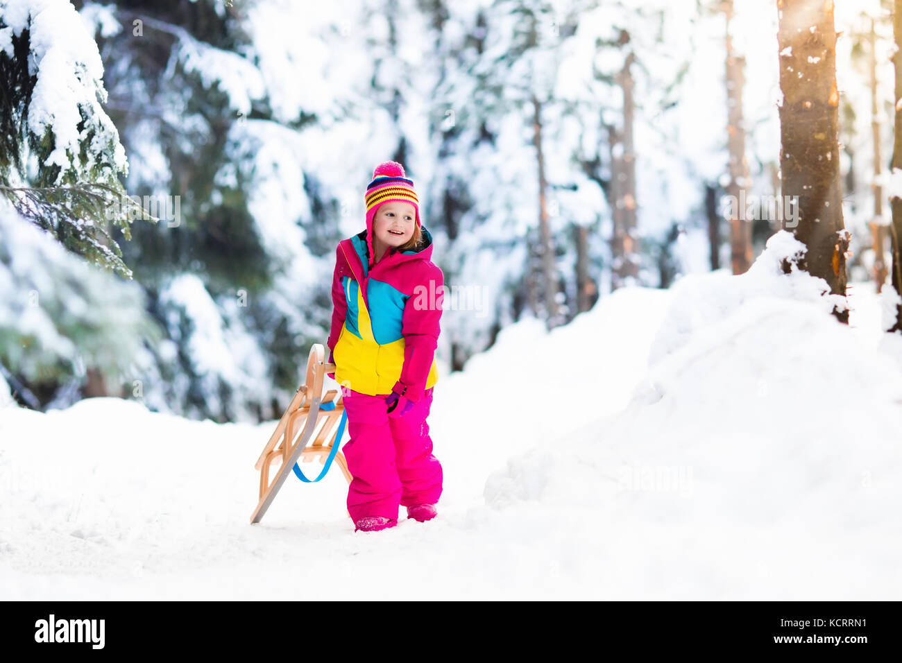 Little girl enjoying a sleigh ride. Child sledding. Toddler kid riding ...