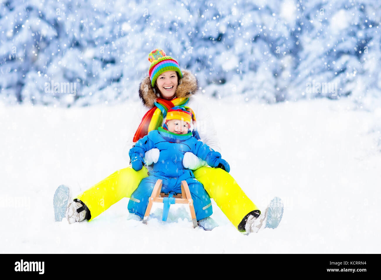 Mother and baby on sleigh ride. Child and mom sledding. Toddler kid ...