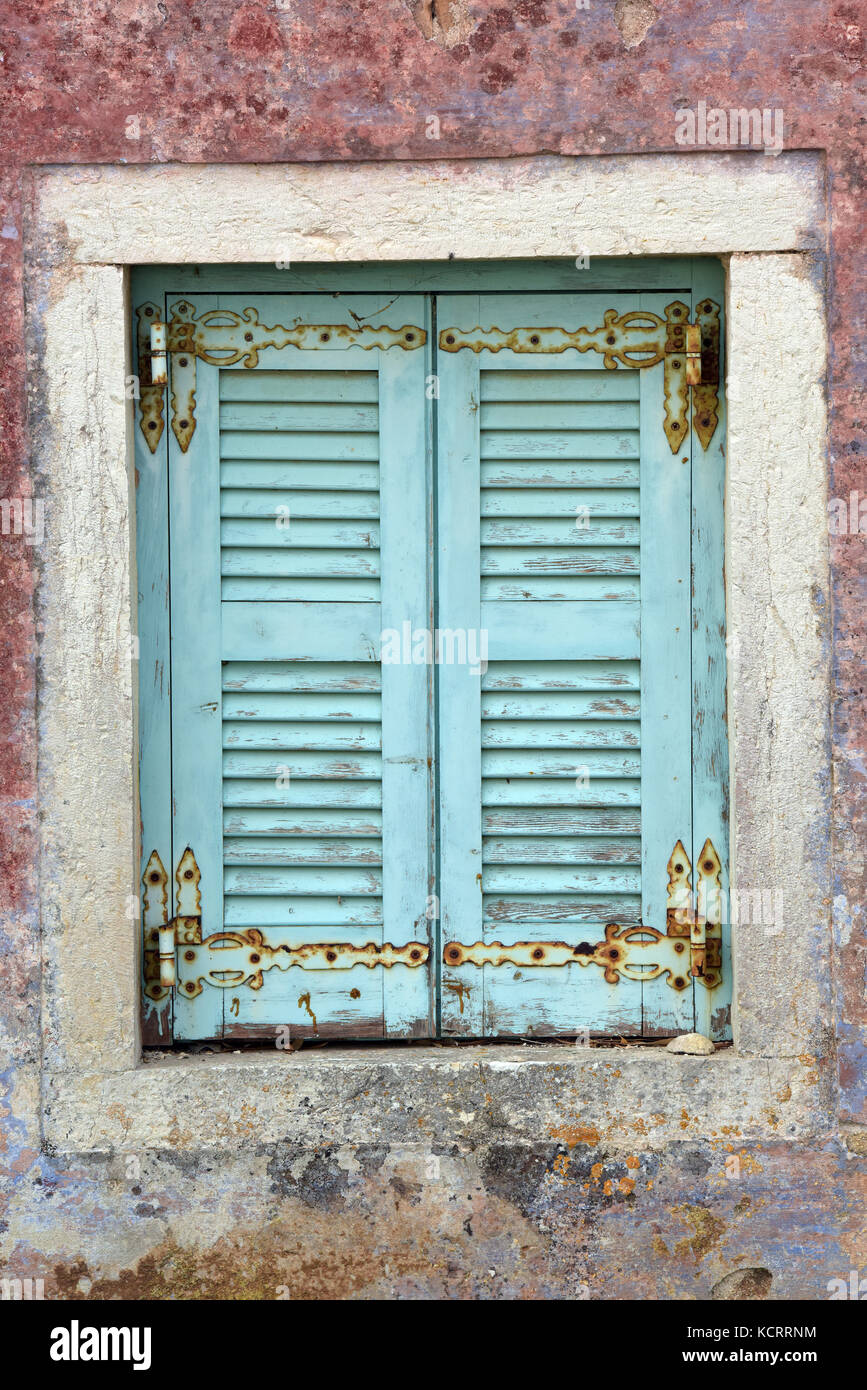 an old greek building in a poor state of repair with peeling green and ...