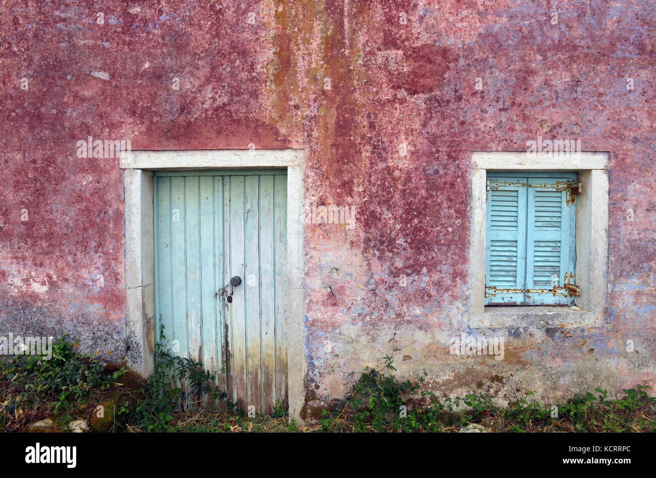 an old greek building in a poor state of repair with peeling green and ...