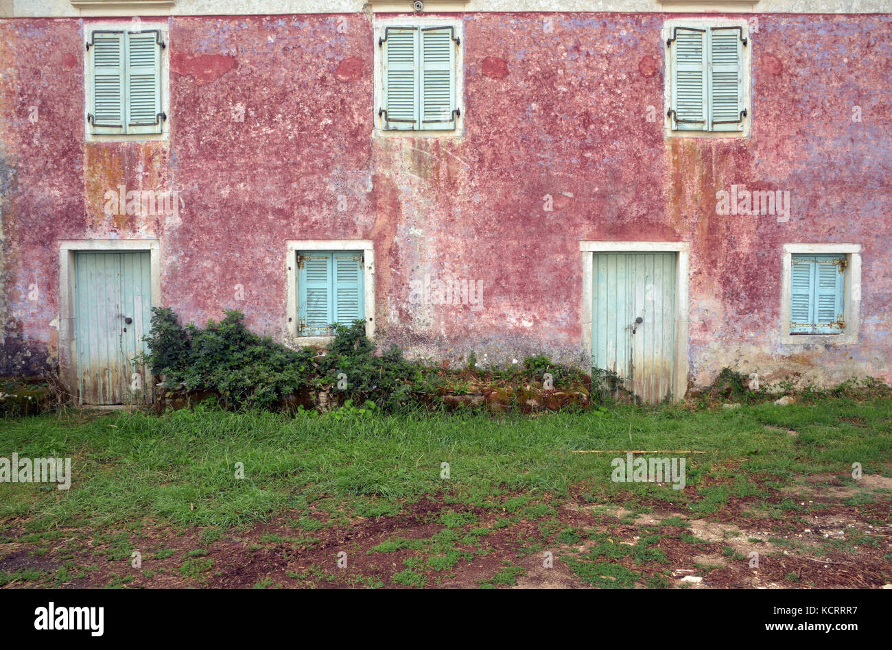 an old greek building in a poor state of repair with peeling green and ...