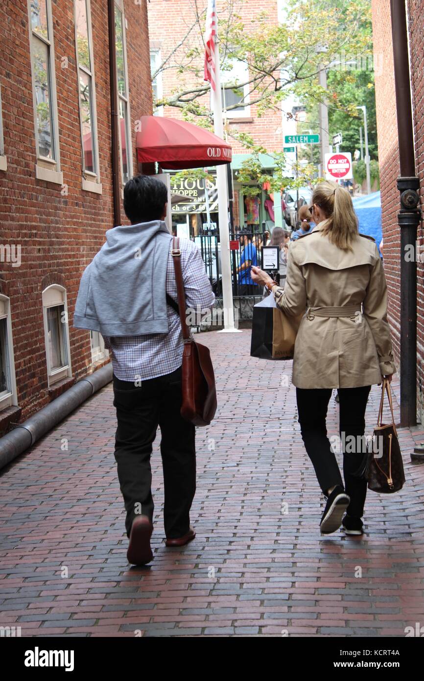A fancy couple walks down the street in the city during the day after ...