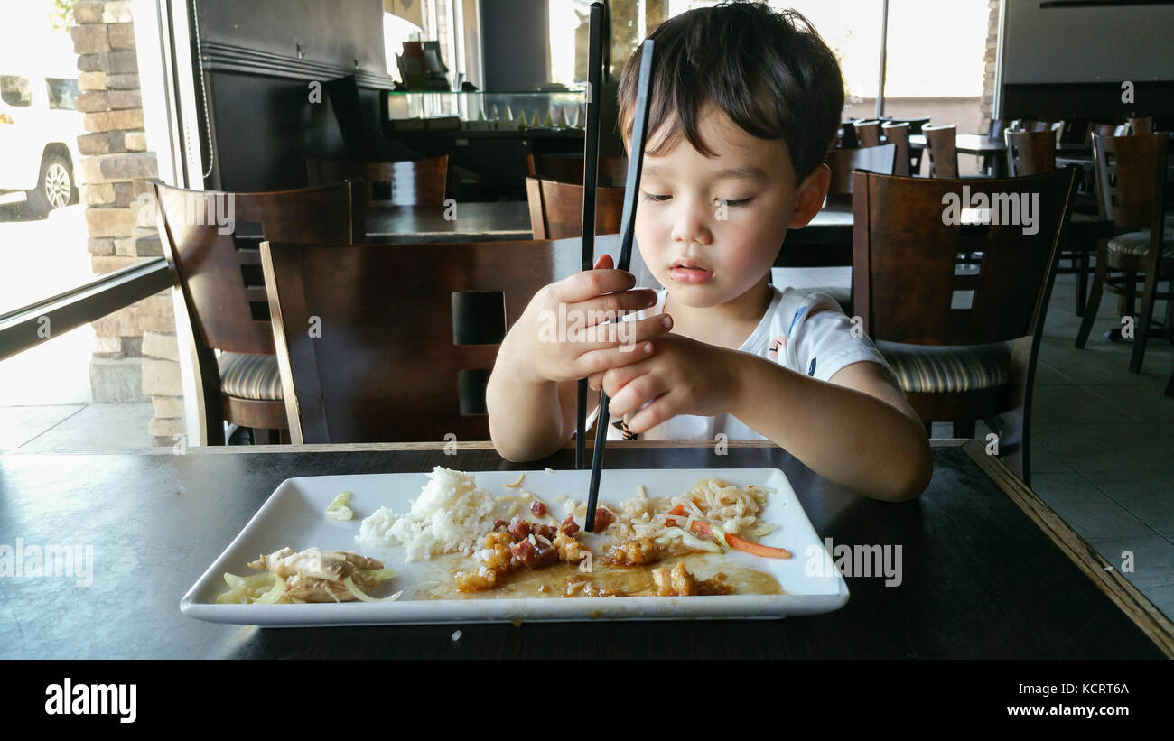 Cute Young Chinese and Caucasian Boy Learning To Use Chopsticks At ...