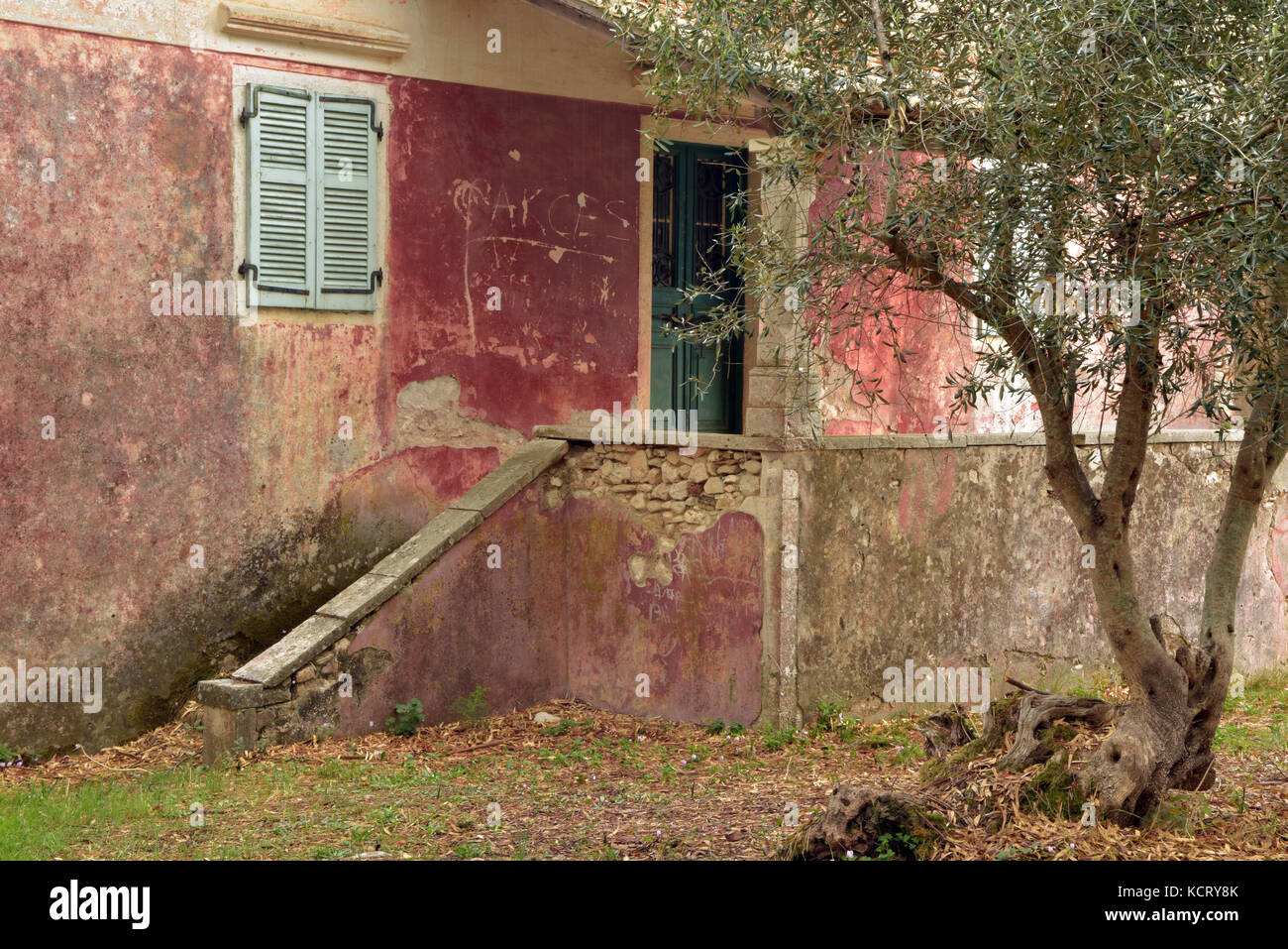 an old greek building in a poor state of repair with peeling green and ...