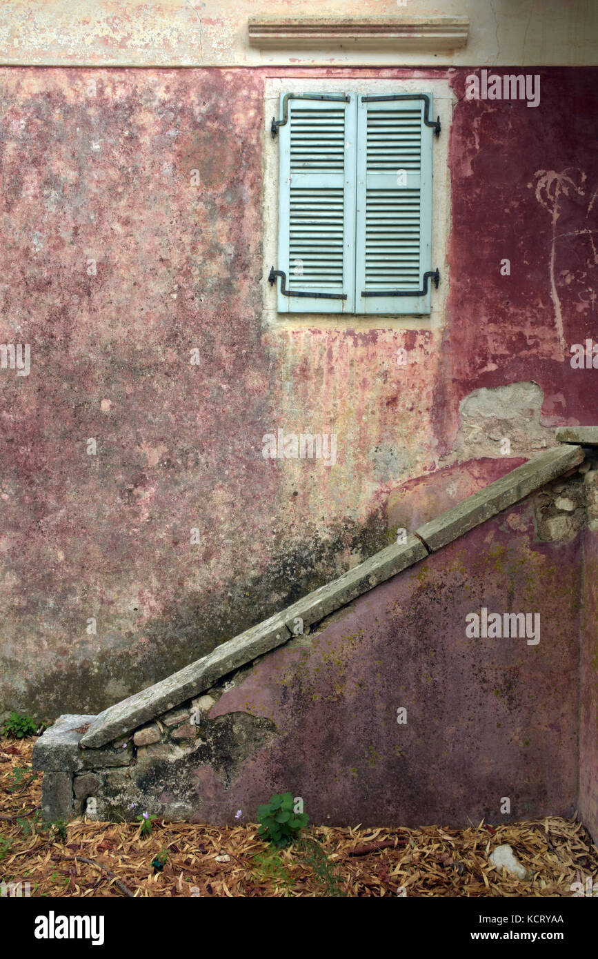 an old greek building in a poor state of repair with peeling green and ...