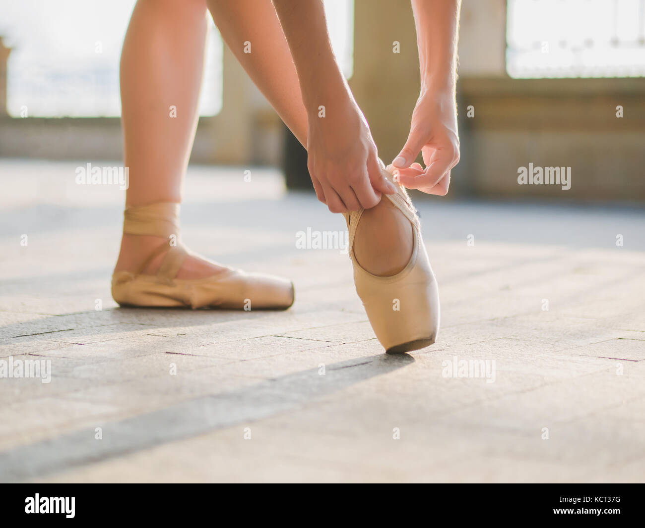 Close up of a ballet dancer's feet as she practices pointe exercises on ...