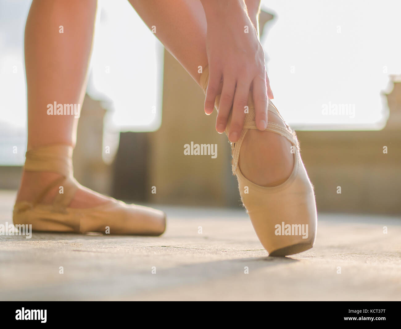 Close up of a ballet dancer's feet as she practices pointe exercises on ...