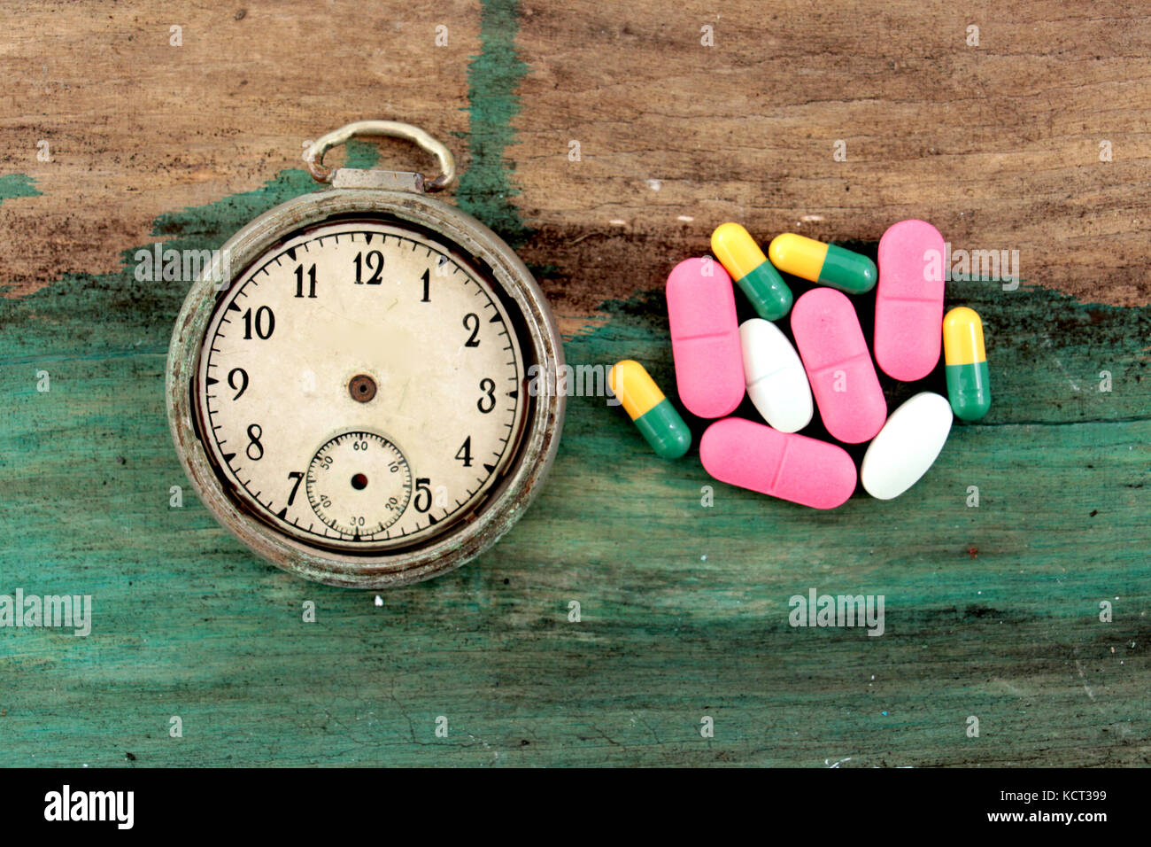 Many colorful pills and capsules and vintage clock Stock Photo - Alamy