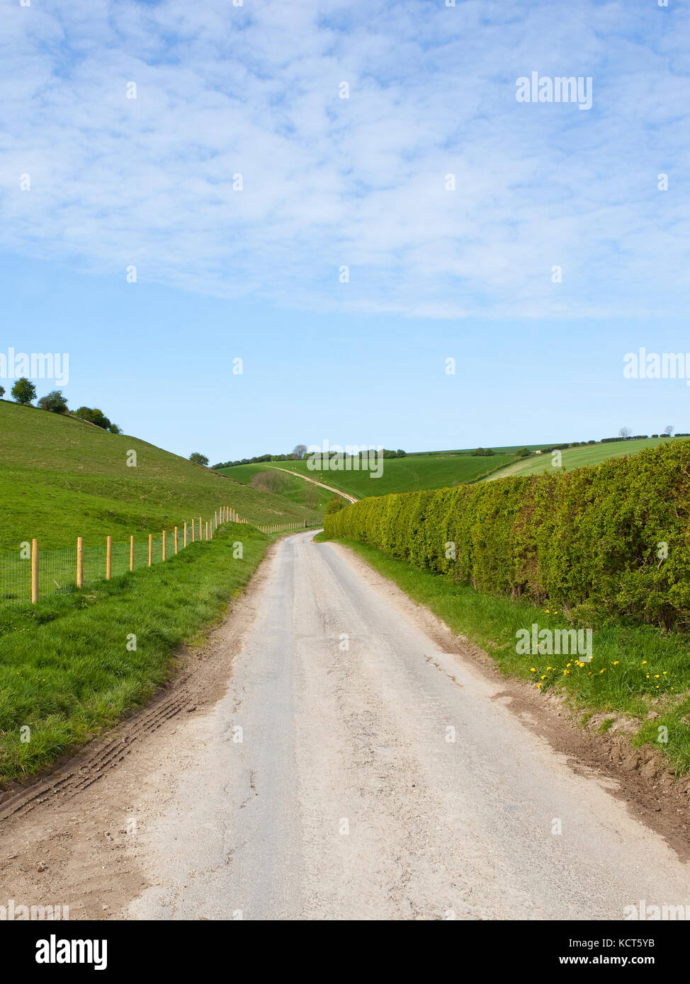 a small country road going through hilly agricultural land with ...