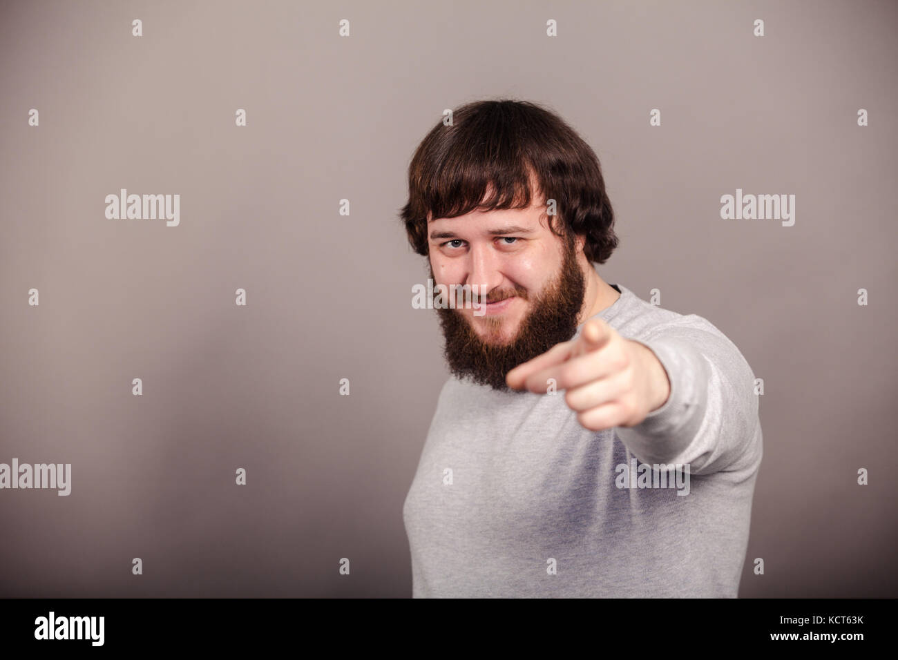 Businessman pointing left hand not straight forward on dark background ...