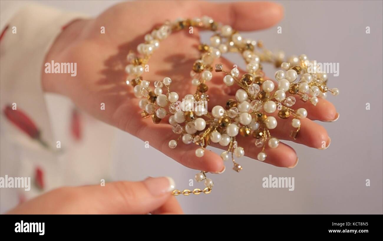 Bride holds in his hands a necklace. Bride holds in hand a beautiful ...
