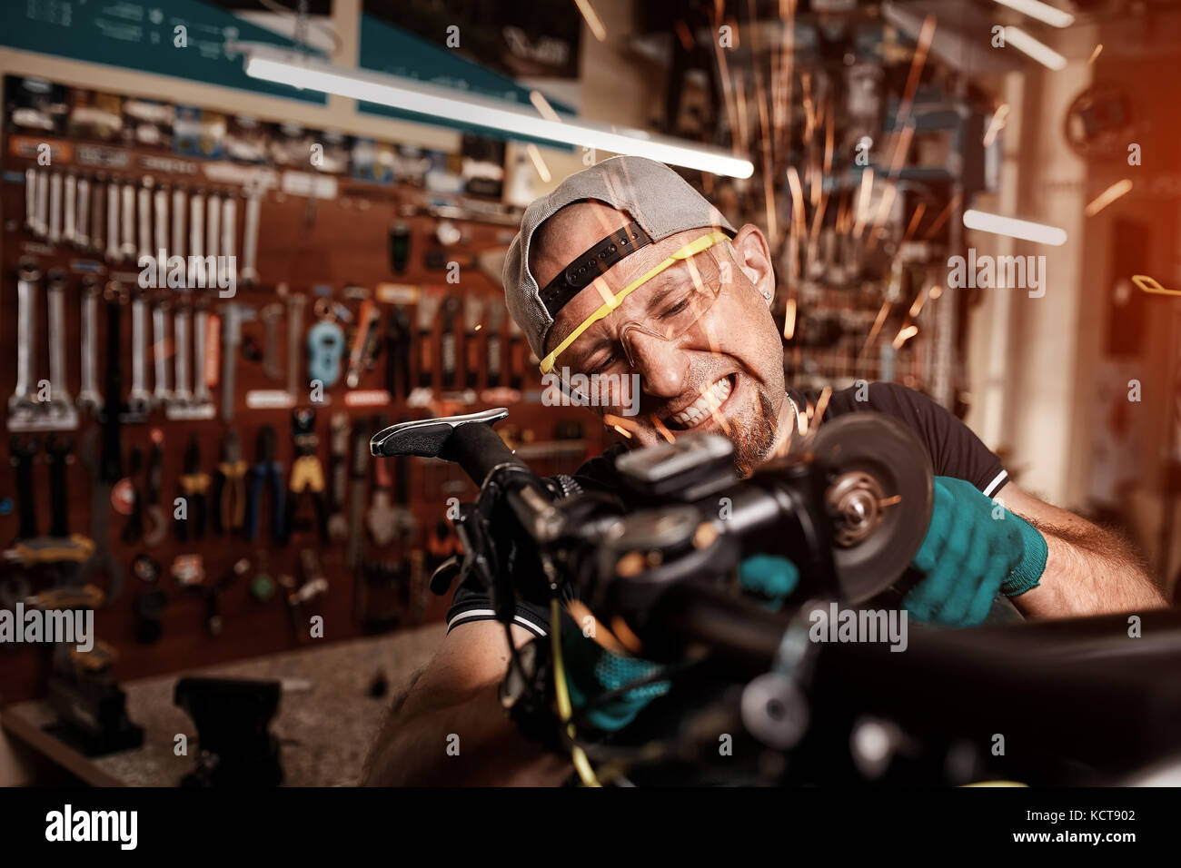 Crazy mechanic saws the bike by circular saw. Funny photo Stock Photo ...