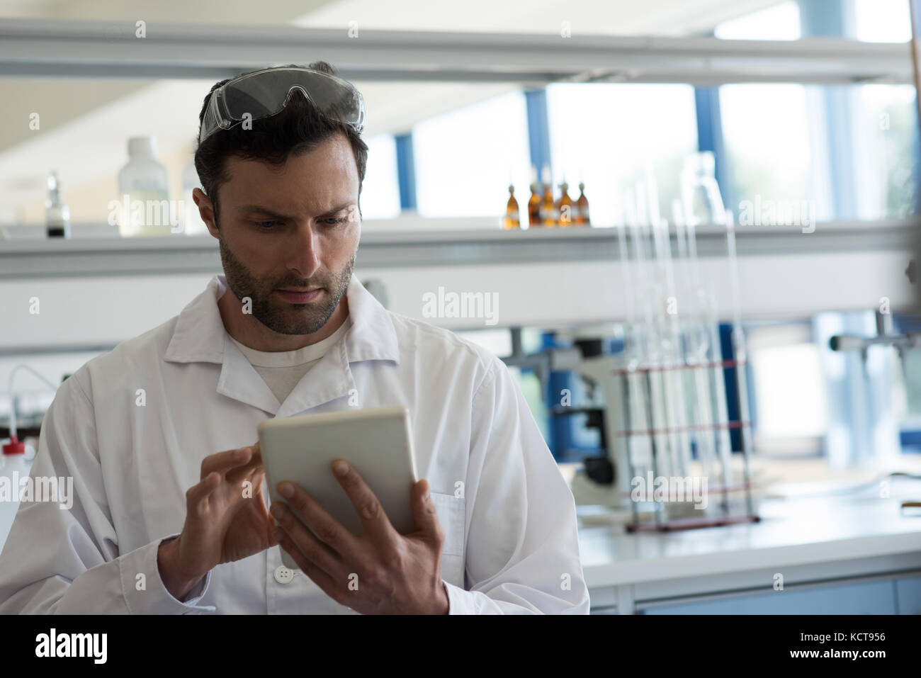 Attentive university student using digital tablet in laboratory Stock ...