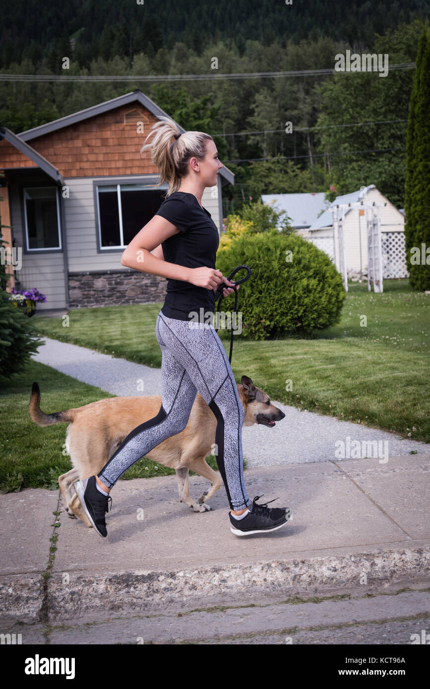 Fit woman jogging with dog Stock Photo - Alamy