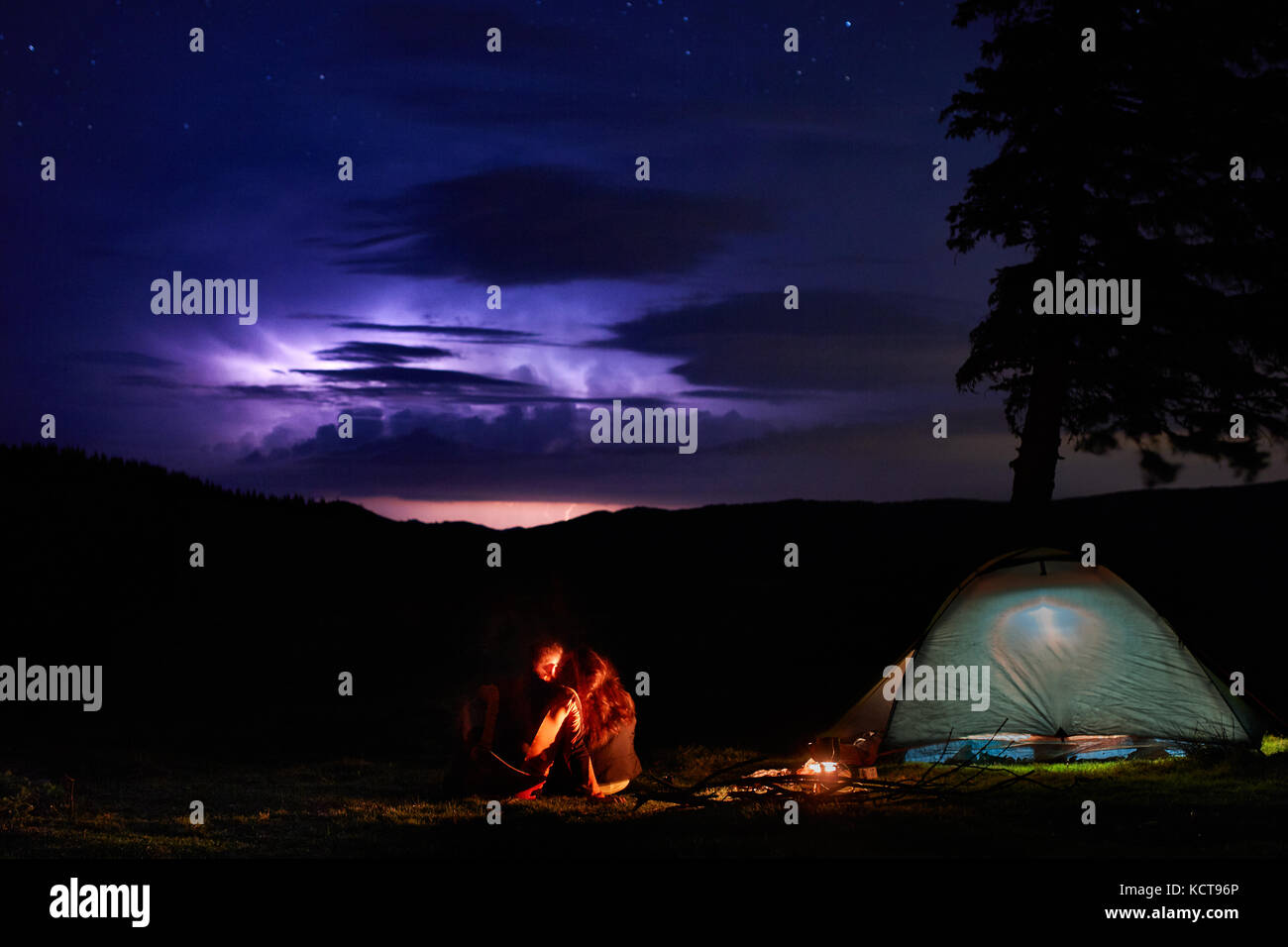 Night camping in the mountains. Couple tourists have a rest at a ...