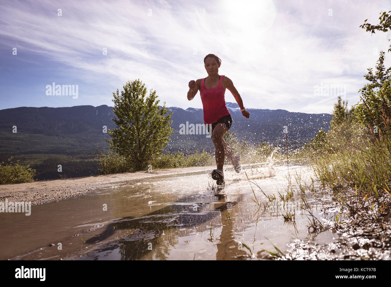 Fit woman jogging in water on a sunny day Stock Photo - Alamy