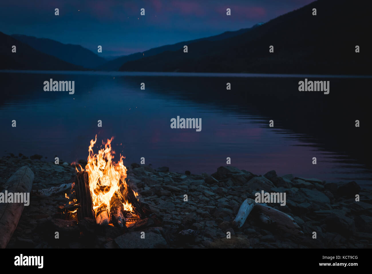 Campfire near lakeside at night Stock Photo - Alamy