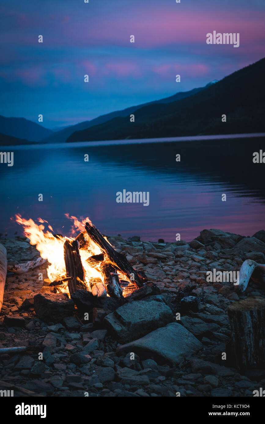 Campfire near lakeside at night Stock Photo - Alamy