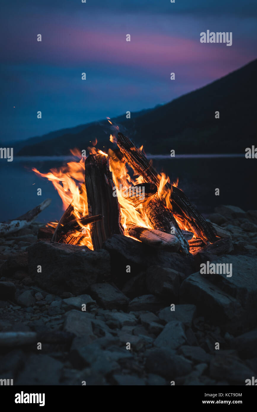 Campfire near lakeside at night Stock Photo - Alamy