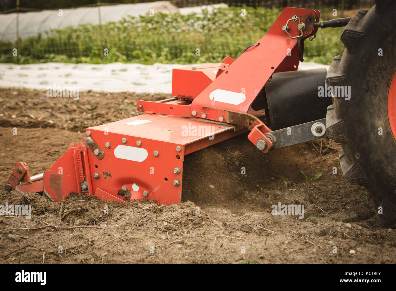 Tractor ploughing field to prepare for seeding in countryside landscape ...