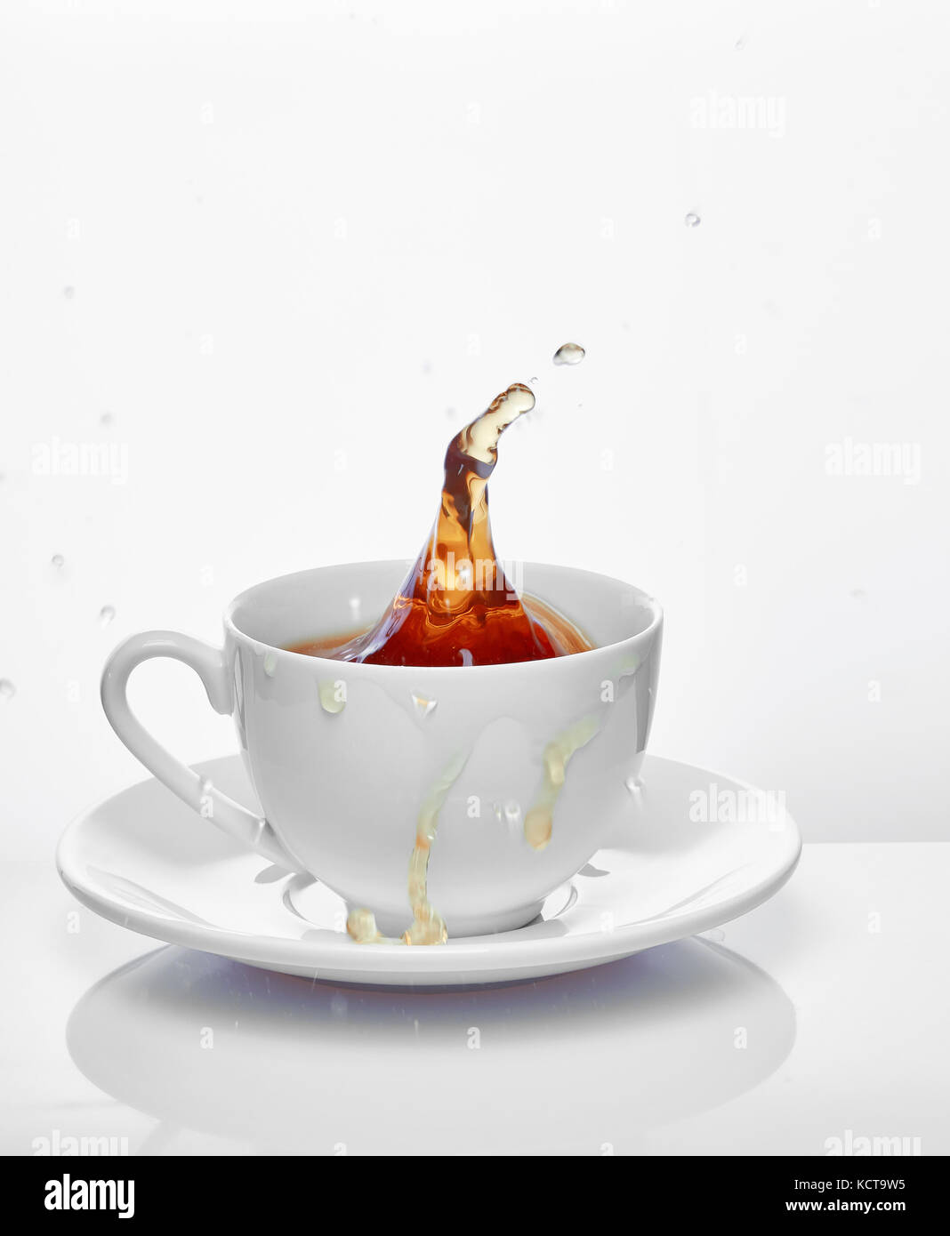 Splash of tea in the cup isolated on white Stock Photo - Alamy