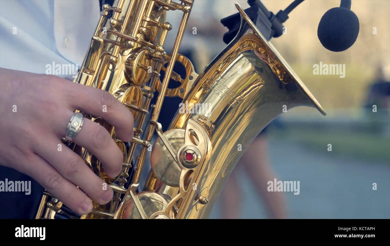 Hands of groom play on saxophone. Closeup hands of man playing golden ...