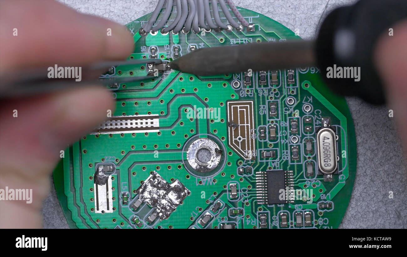 Microcircuit being fixed with soldering iron. Computer repair concept ...