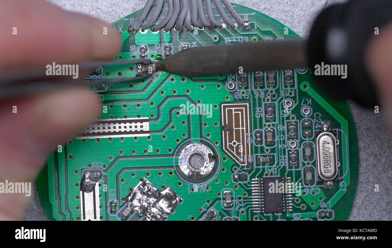 Microcircuit being fixed with soldering iron. Computer repair concept ...