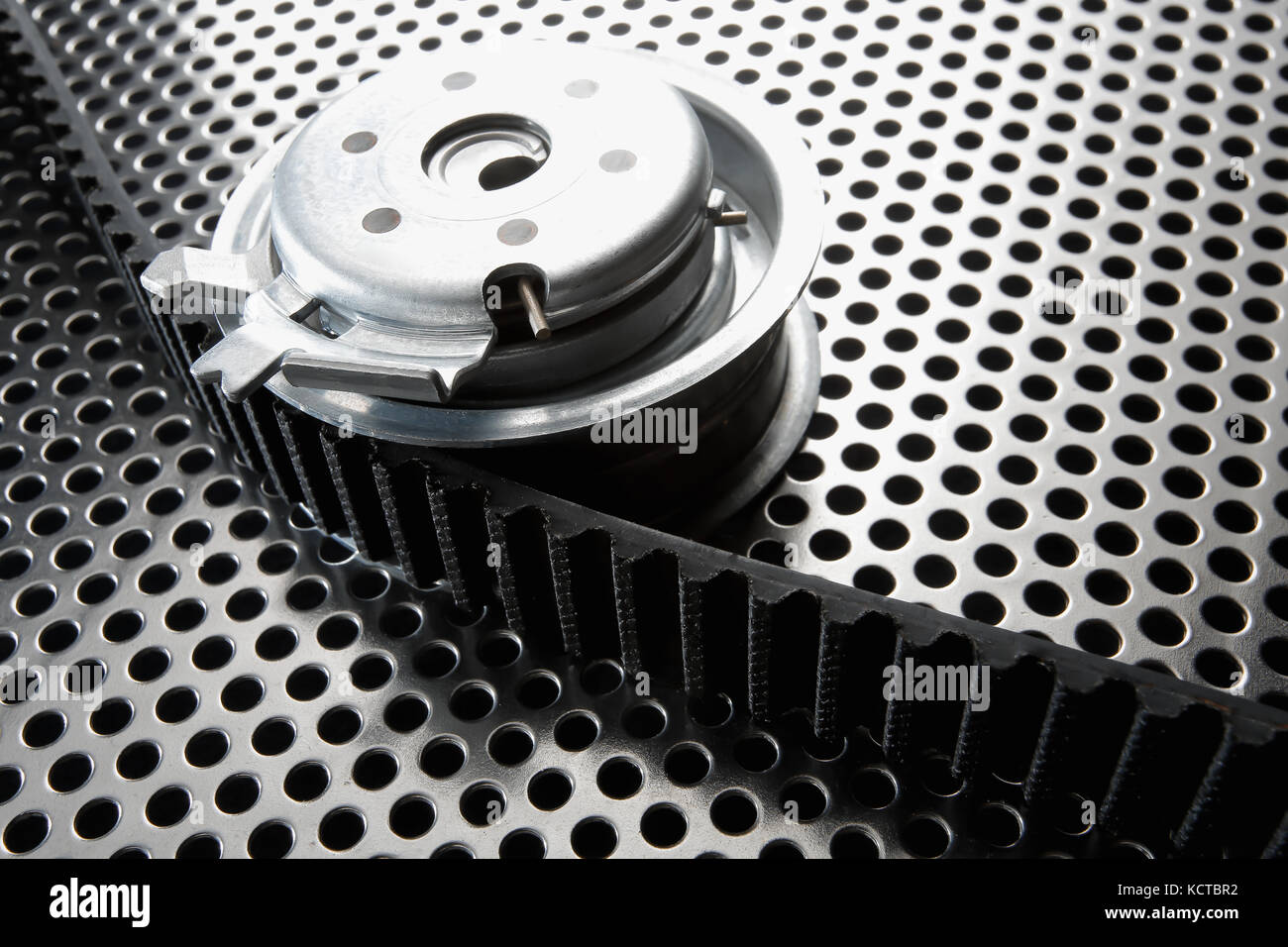 Bearing tensioner and timing belt on a metal surface. Photo from the ...