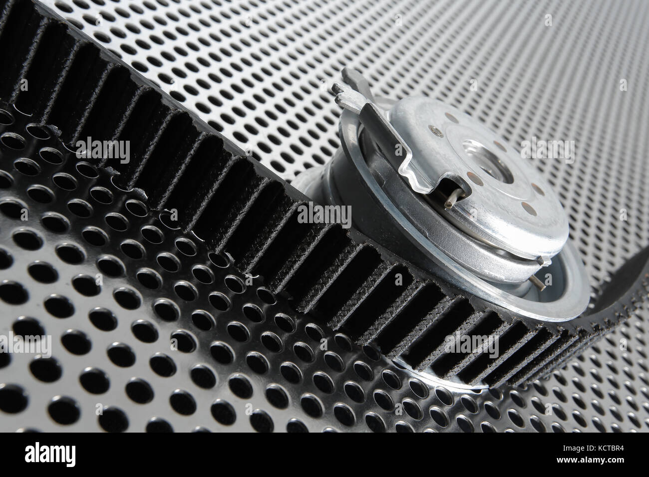 Bearing tensioner and timing belt on a metal surface. Photo from the ...