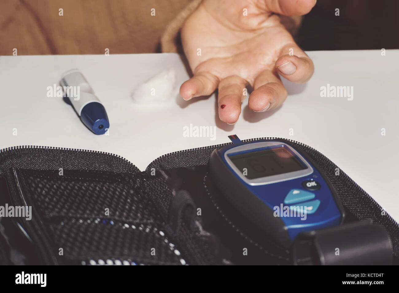 Applying a drop of blood on a test strip for measuring the level of ...