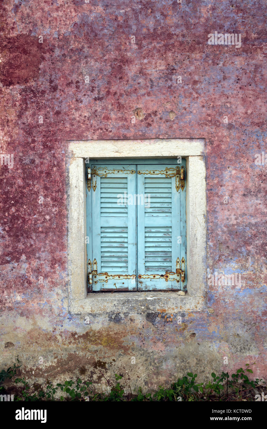 an old greek building in a poor state of repair with peeling green and ...