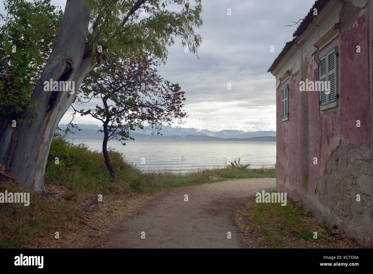an old greek building in a poor state of repair with peeling green and ...