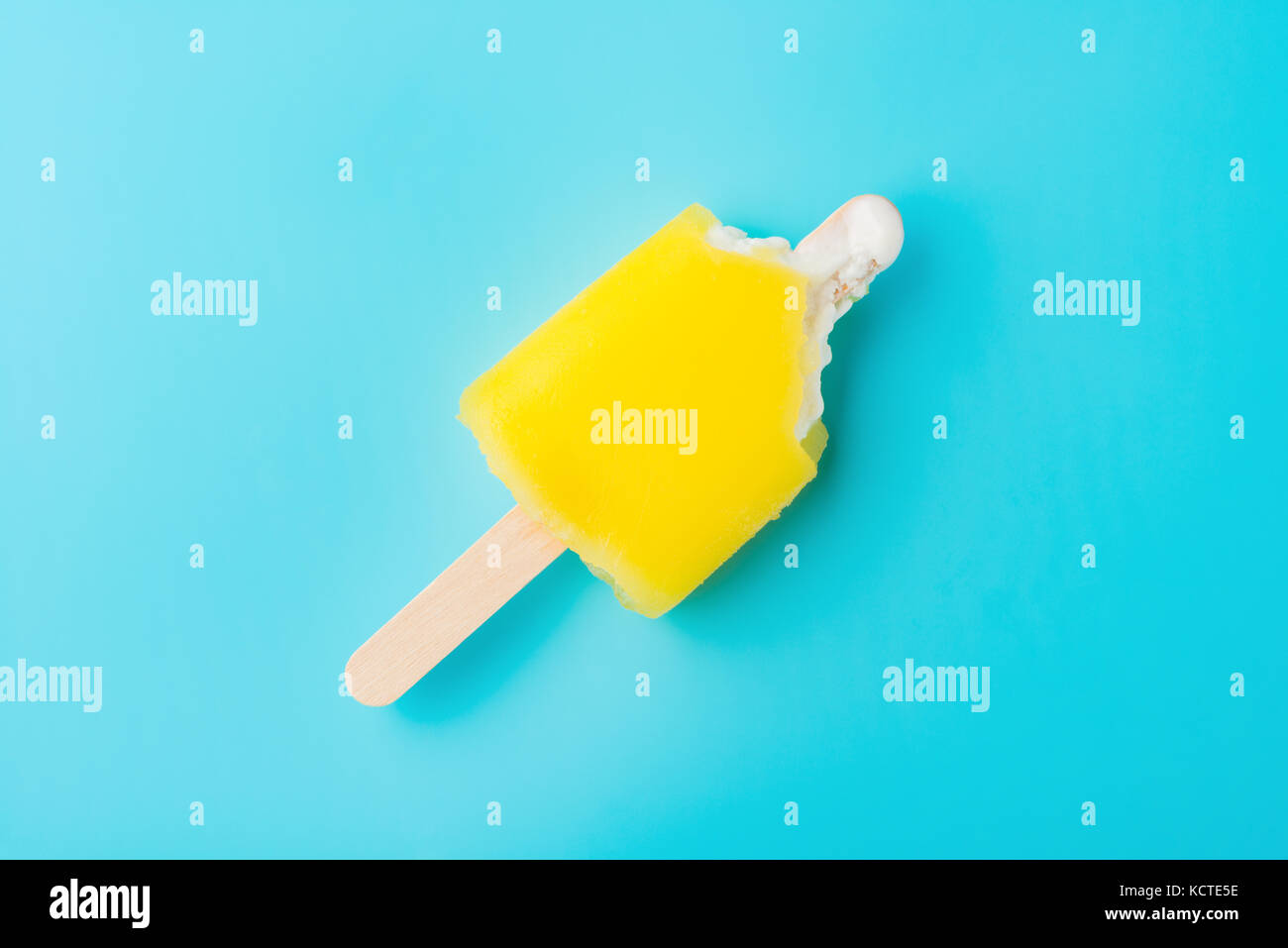top view yellow popsicle with bites on a blue background Stock Photo ...