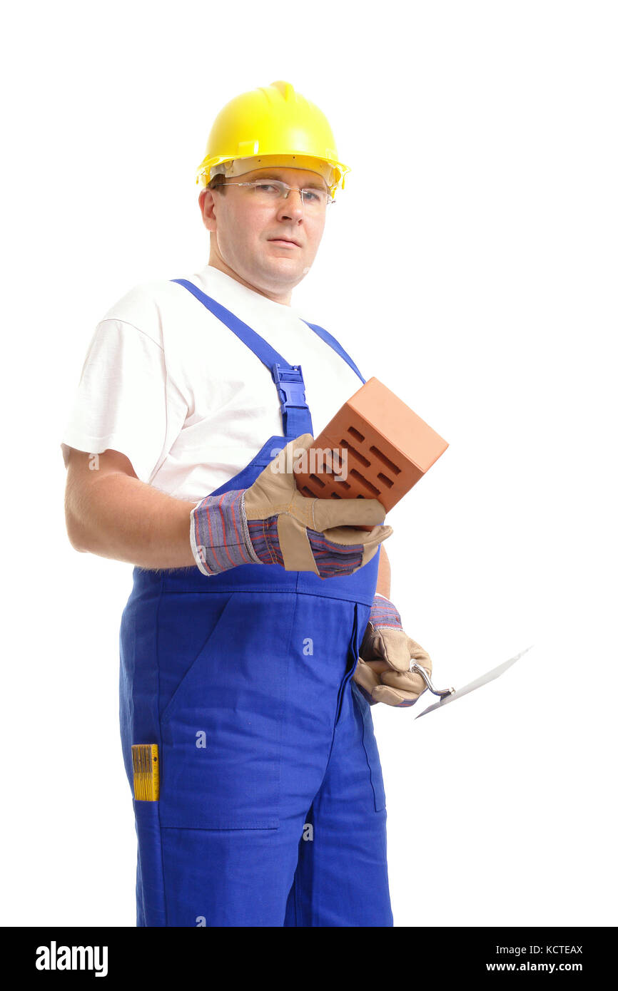 Construction worker wearing blue overall and yellow helmet holding ...