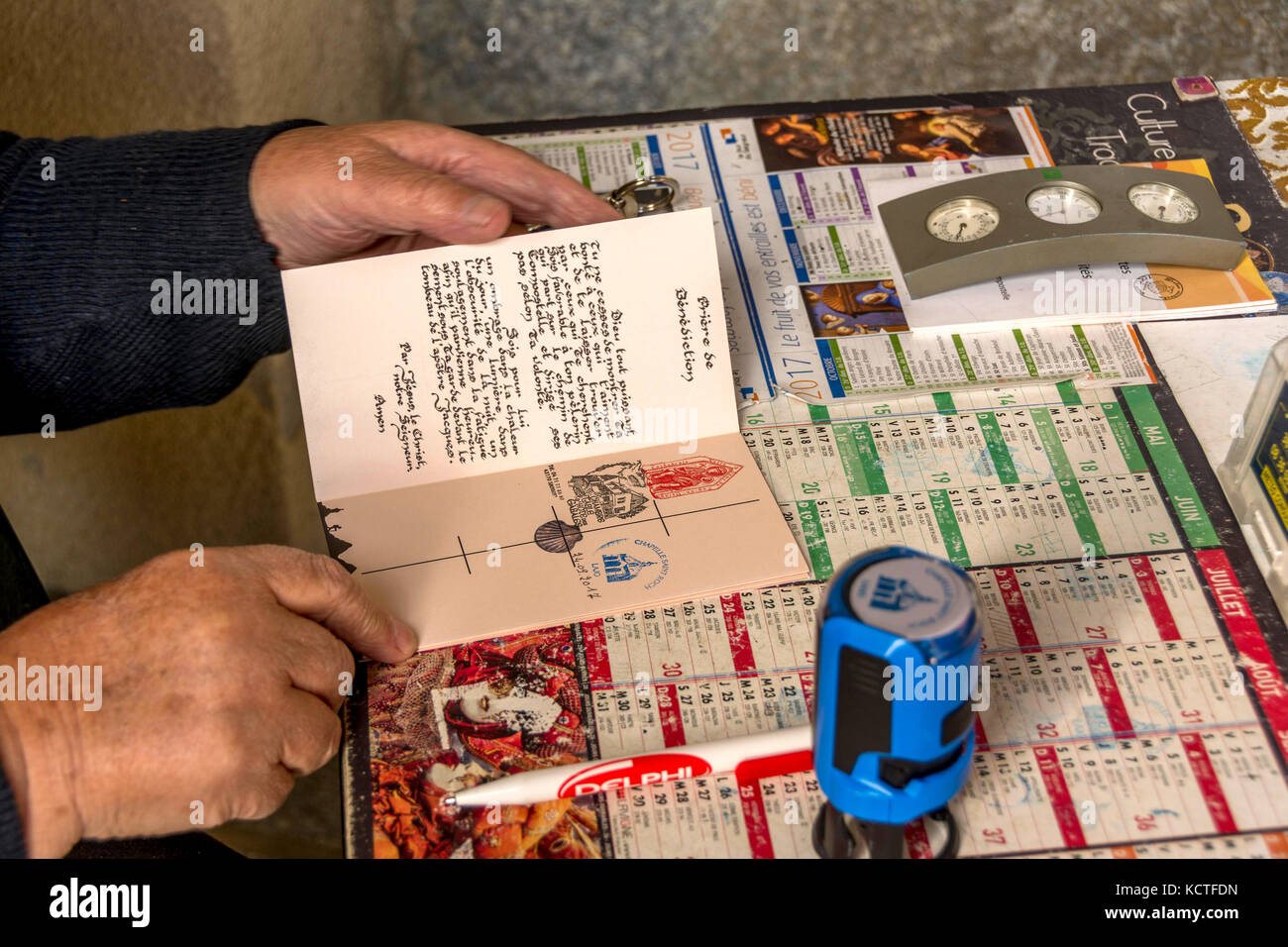 Person stamping a credential in the Saint Roch chapel on Via Podiensis ...