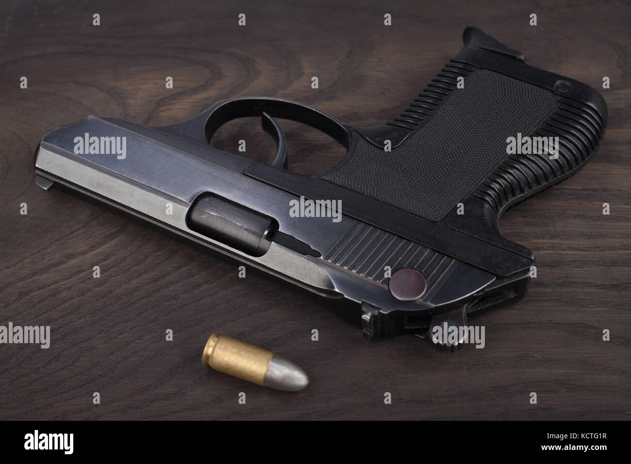 handgun with ammunition on the wooden table Stock Photo - Alamy