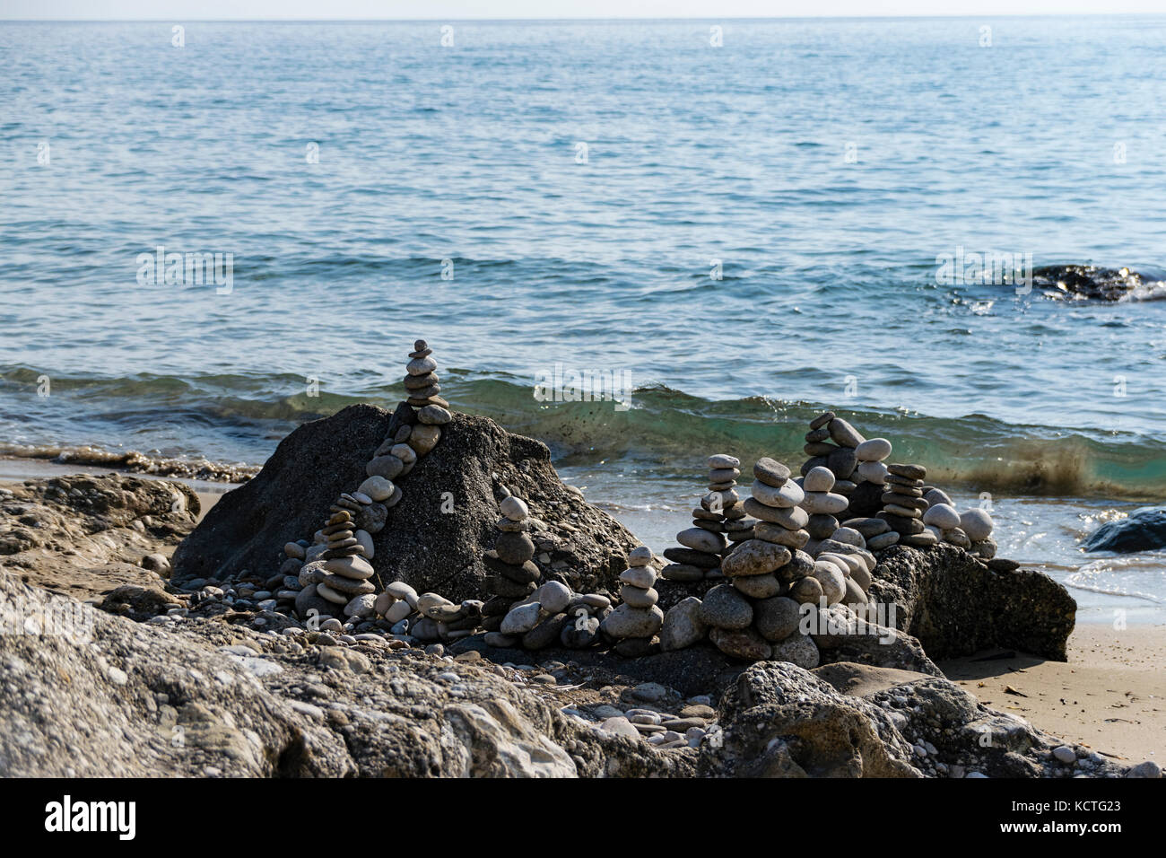 Scenic View Of Balanced Stones Stacked On Rocks Near Beach And Ionian ...
