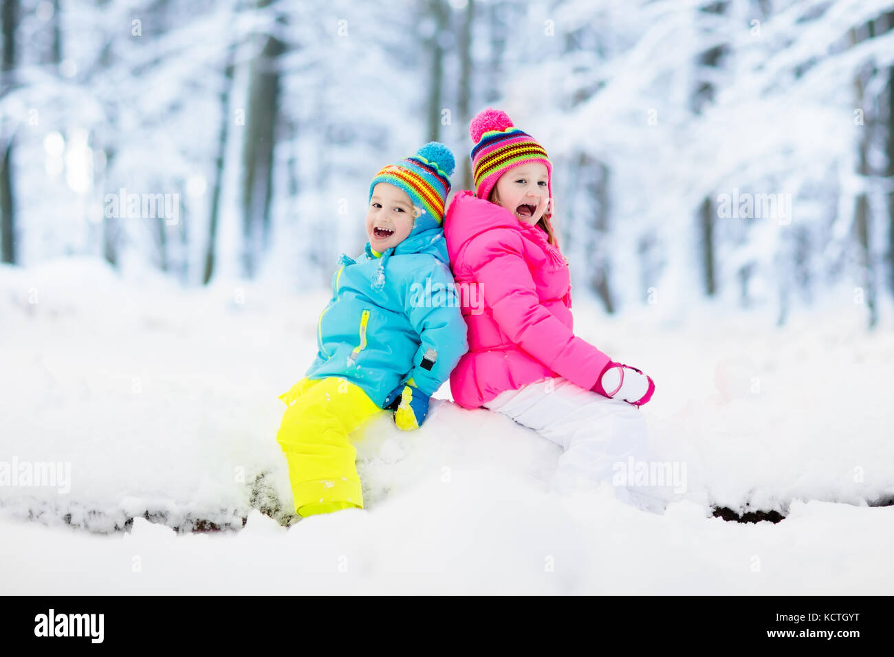Kids playing in snow. Children play outdoors on snowy winter day. Boy ...