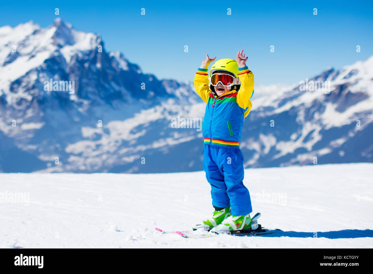 Child skiing in mountains. Active toddler kid with safety helmet ...