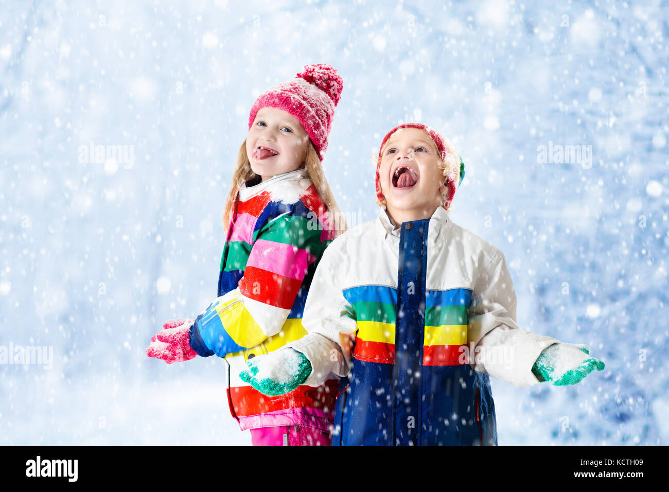 Kids playing in snow. Children play outdoors on snowy winter day. Boy ...
